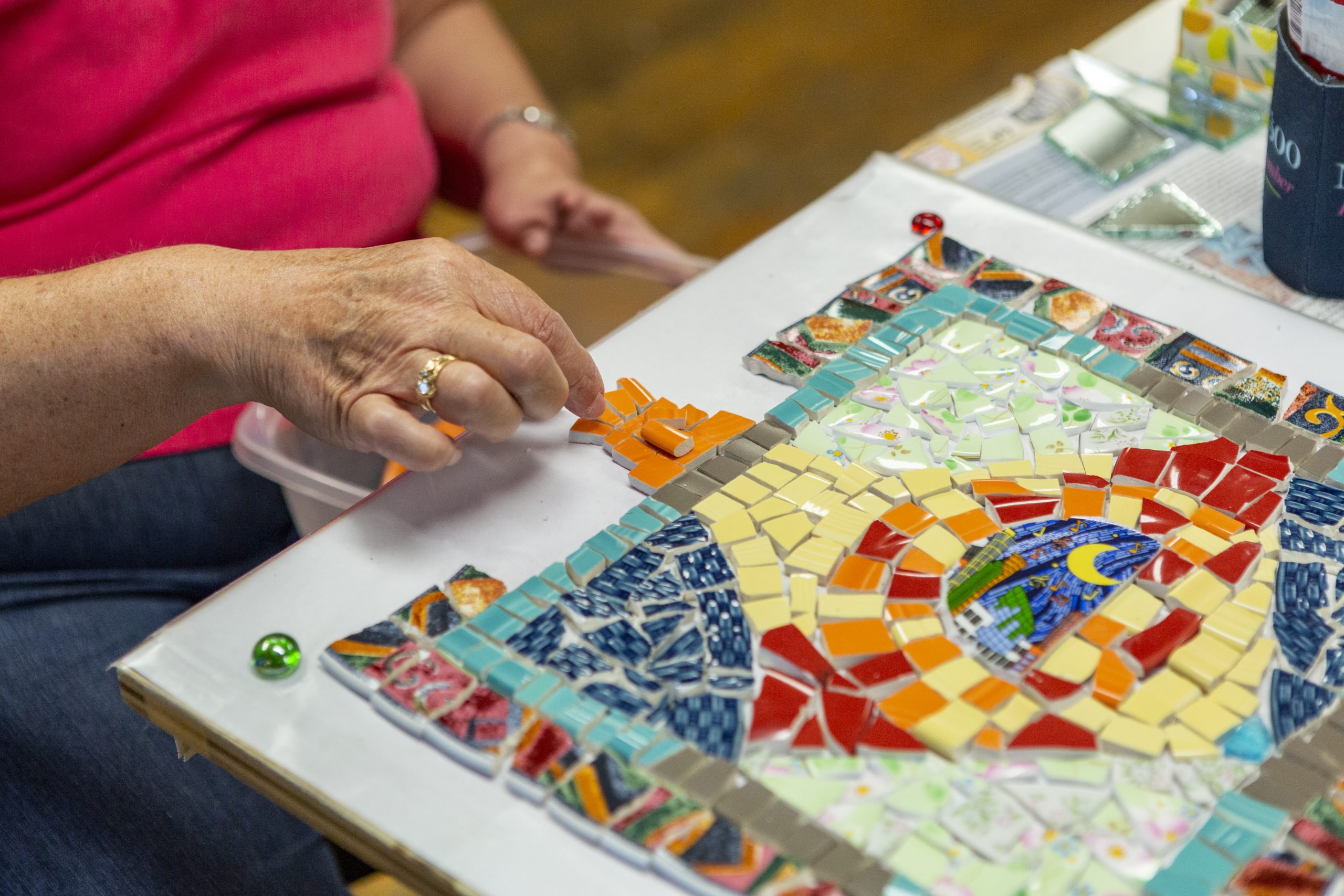 JCCFS | Student making mosaic using broken dishes in one of our classes